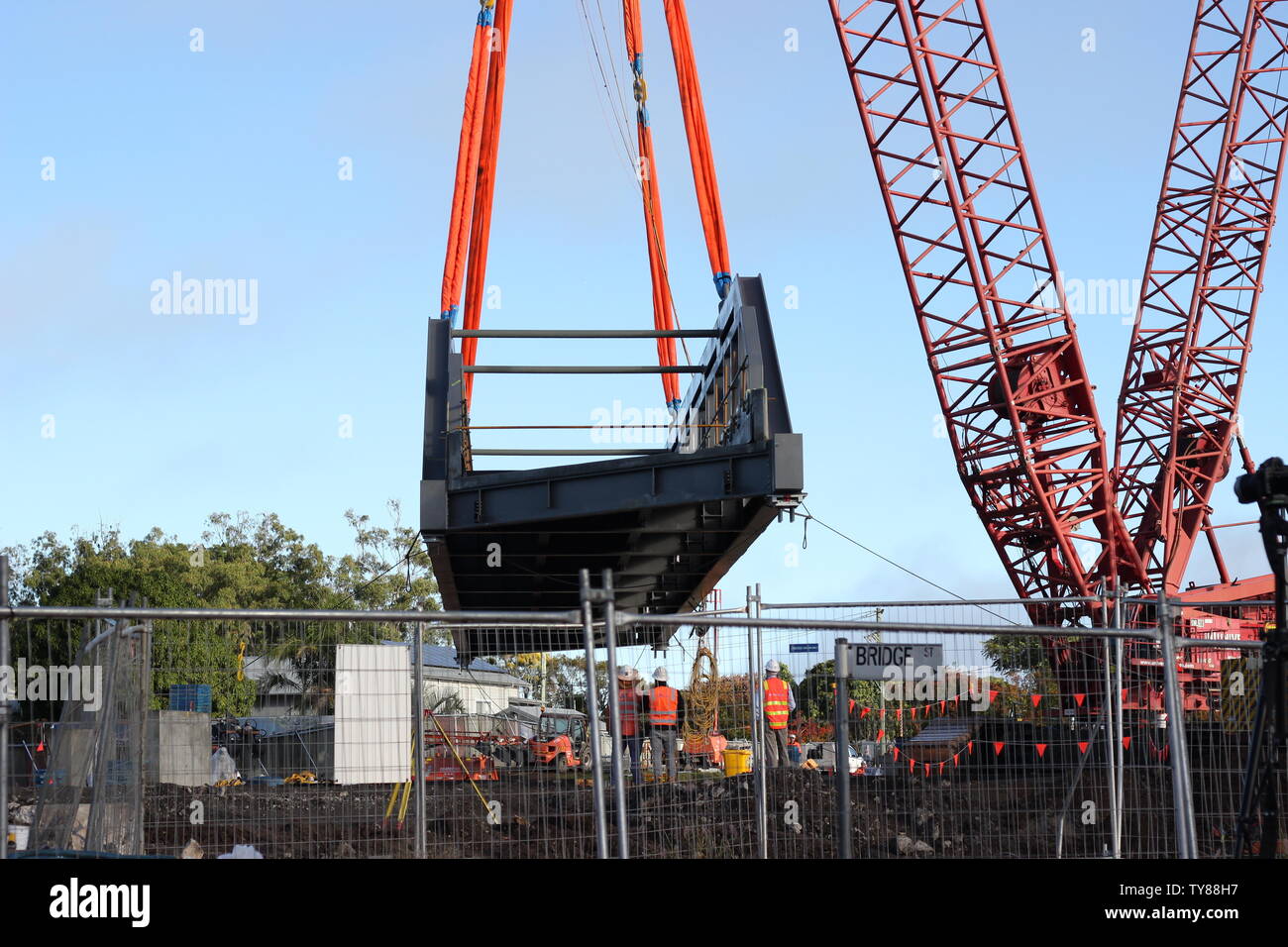 Sequence pictures of large crane lifting steel section of rail bridge ...