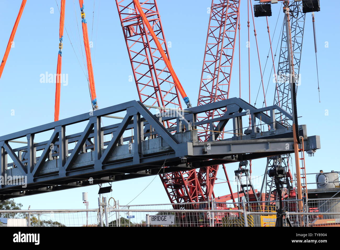 Sequence pictures of large crane lifting steel section of rail bridge ...