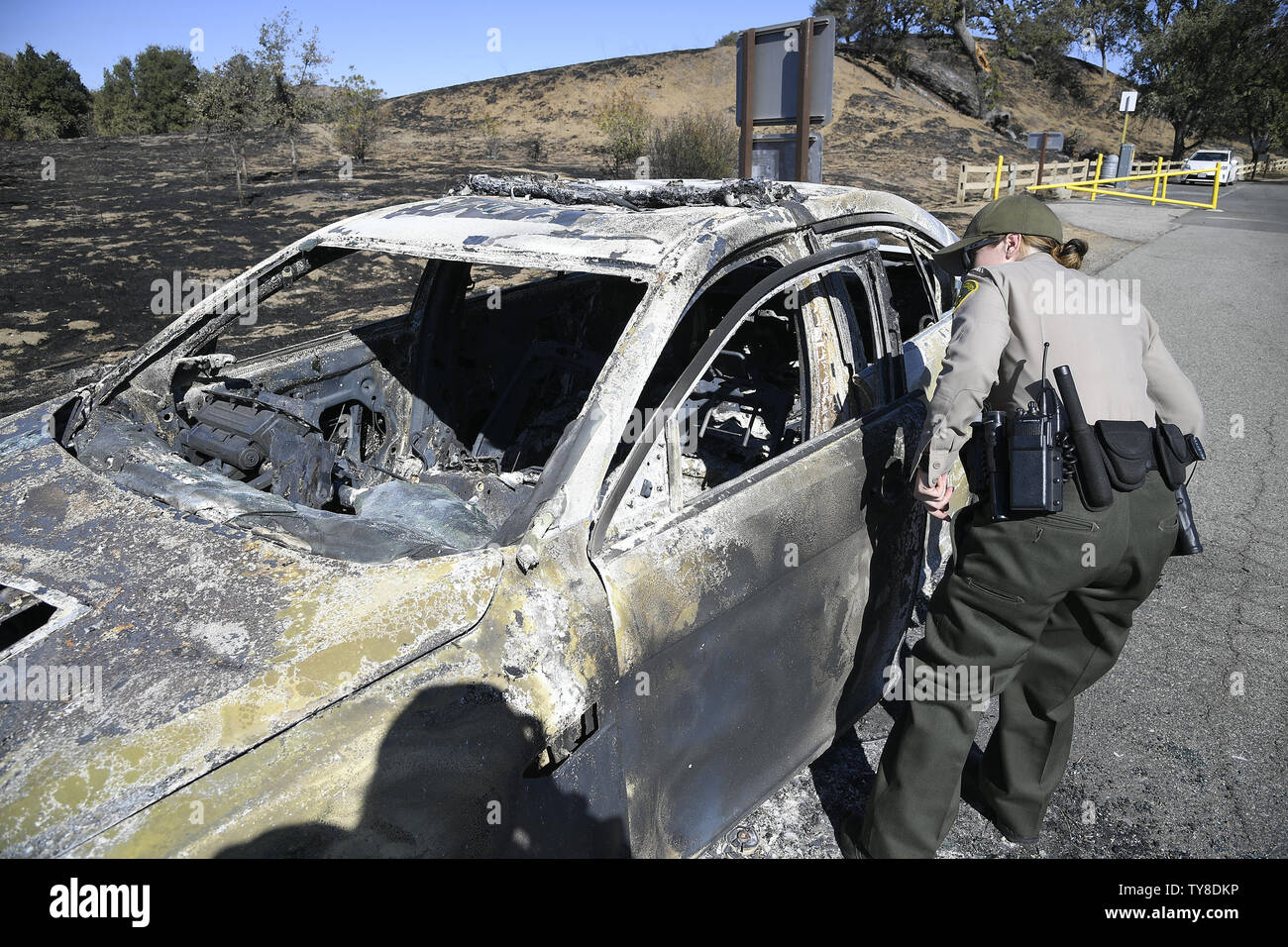 A Sheriffs Deputy looks inside a heavily burned car in the Malubu Creek ...