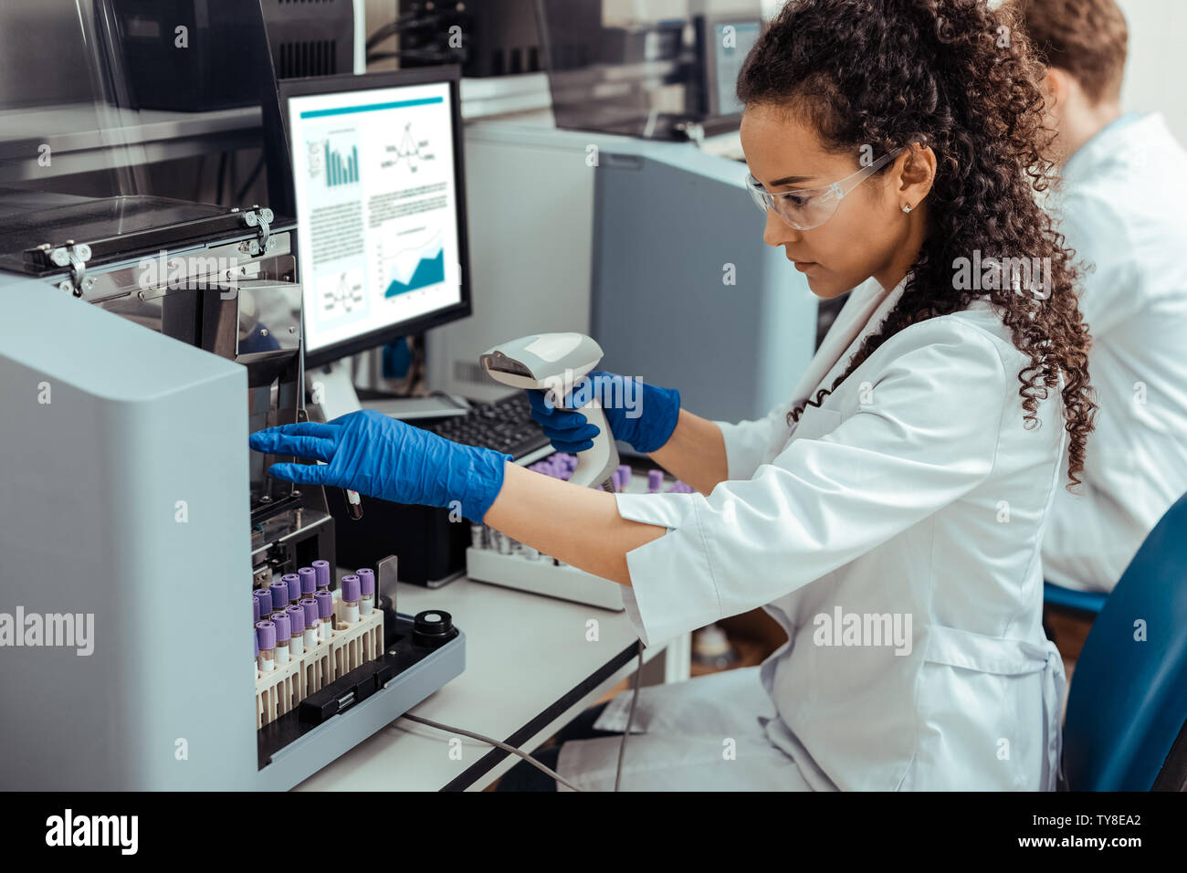 Smart nice woman looking at the test tube Stock Photo - Alamy