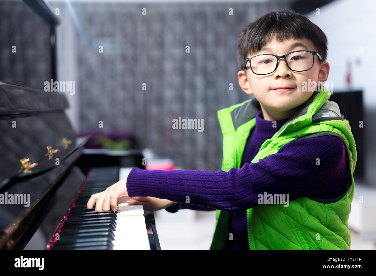 Asian cute boy playing piano at home Stock Photo - Alamy