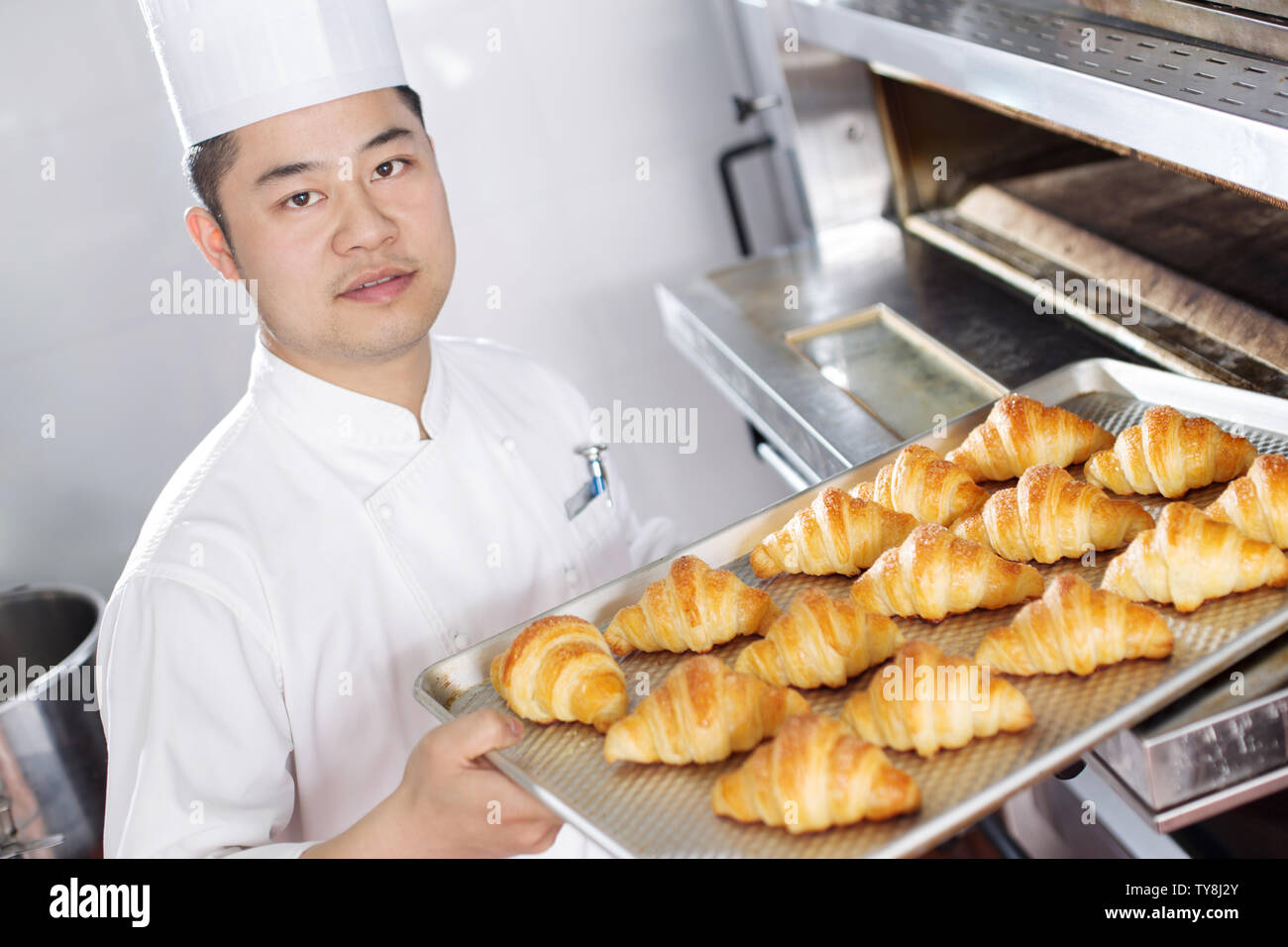 young chinese man chelf making bread in kitchen Stock Photo - Alamy