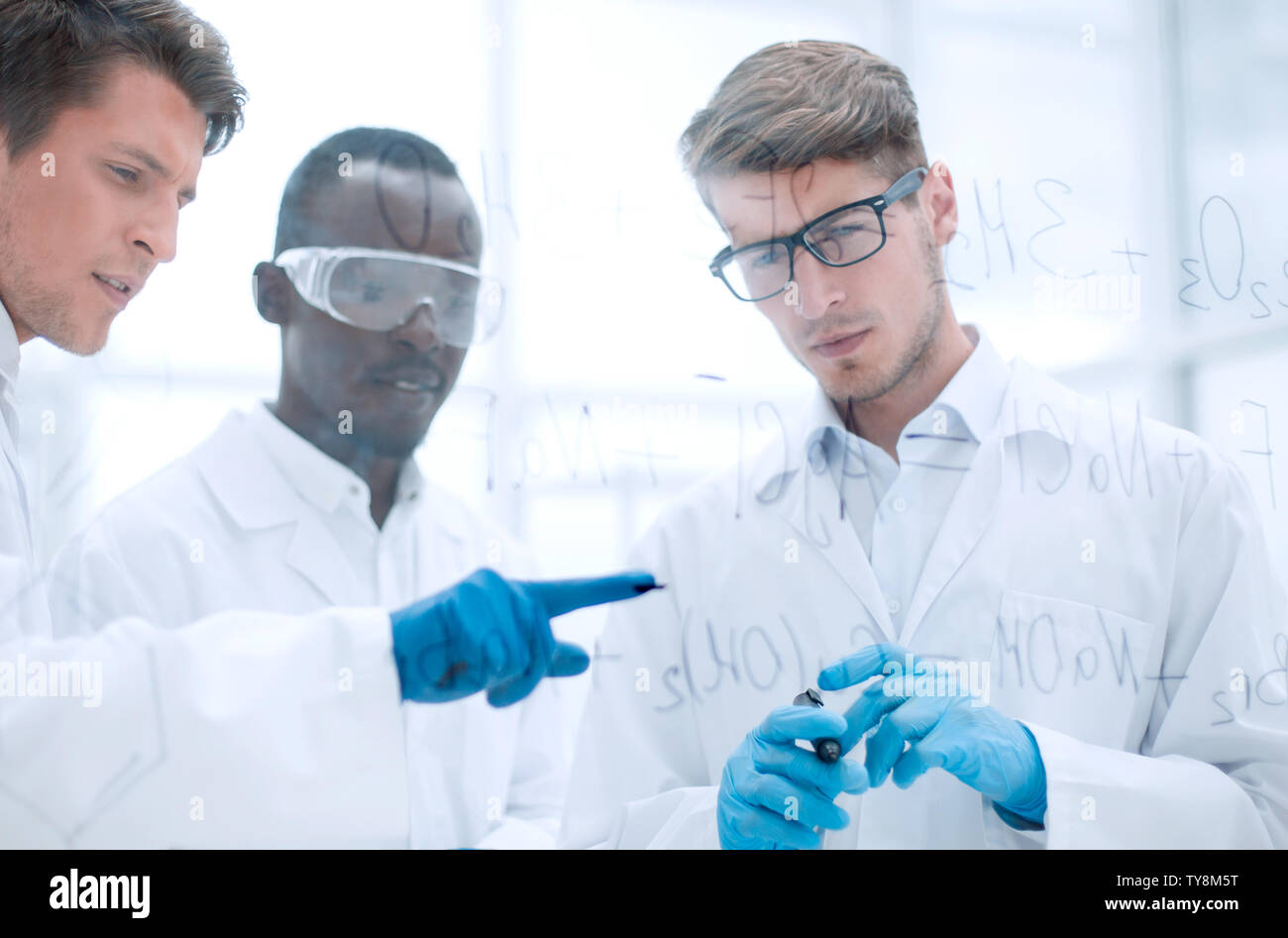group of scientists discussing chemical formulas Stock Photo - Alamy