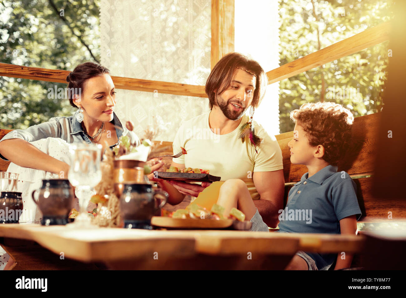 Pleasant cute boy having meal with his family Stock Photo - Alamy