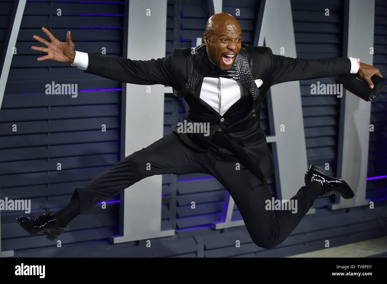 Terry Crews takes a flying jump as he arrives for the Vanity Fair Oscar ...