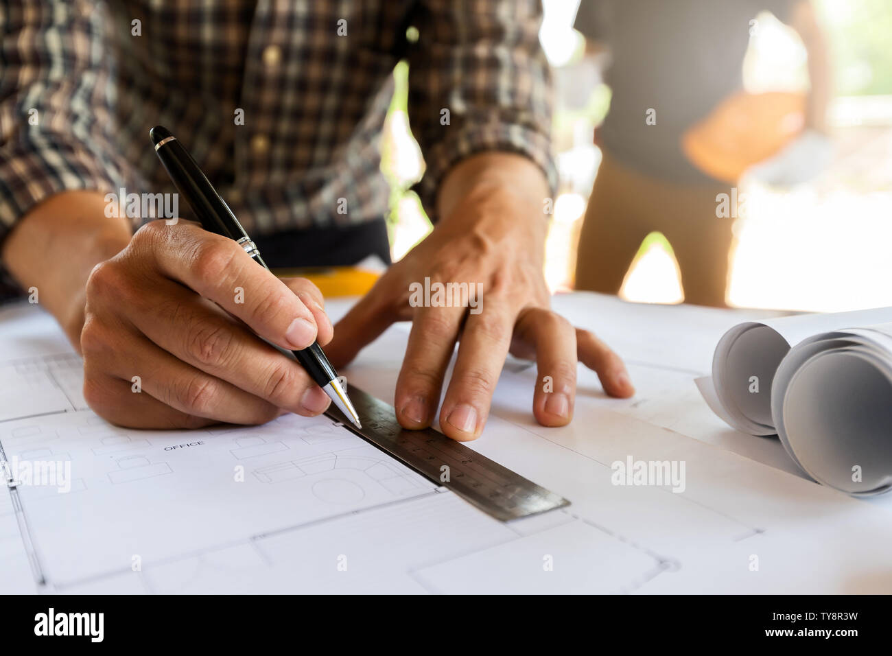 Architect measuring scale on blueprint in construction site Stock Photo ...