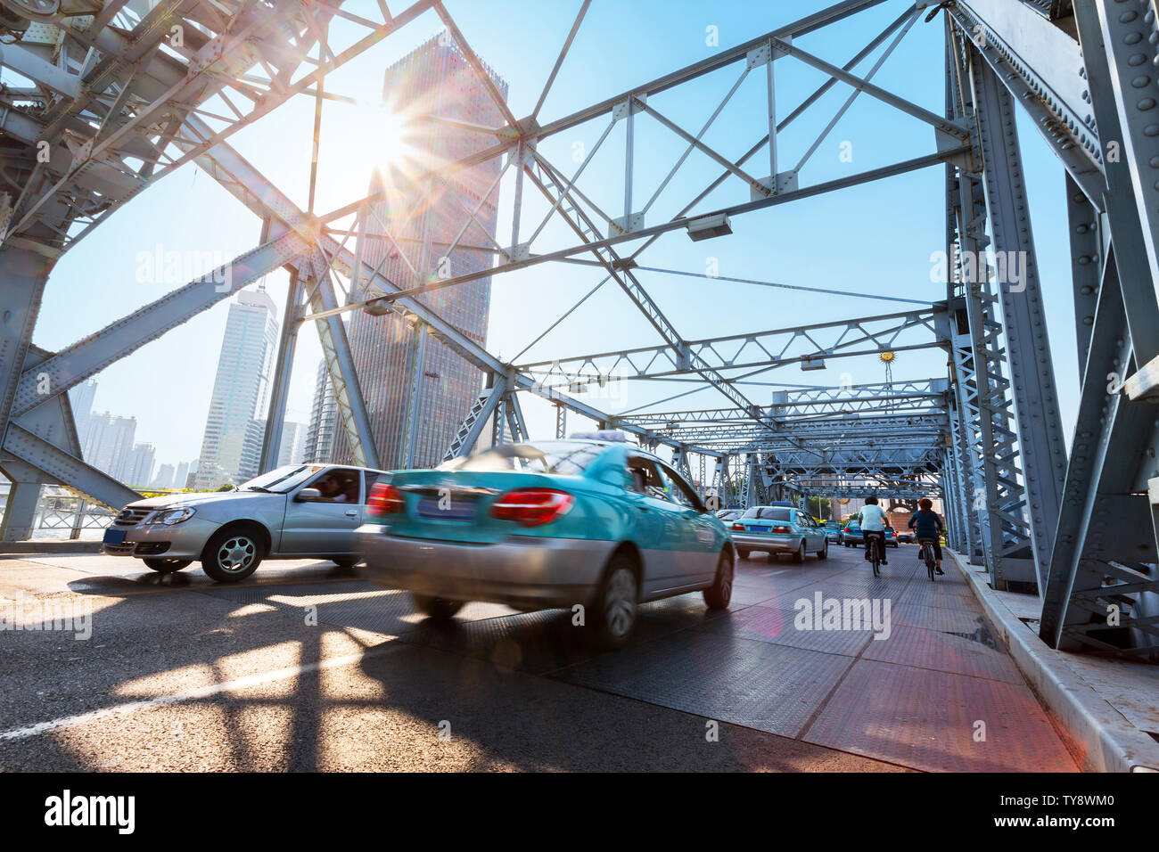 Traffic on steel bridge interior and skyline at sunset Stock Photo - Alamy