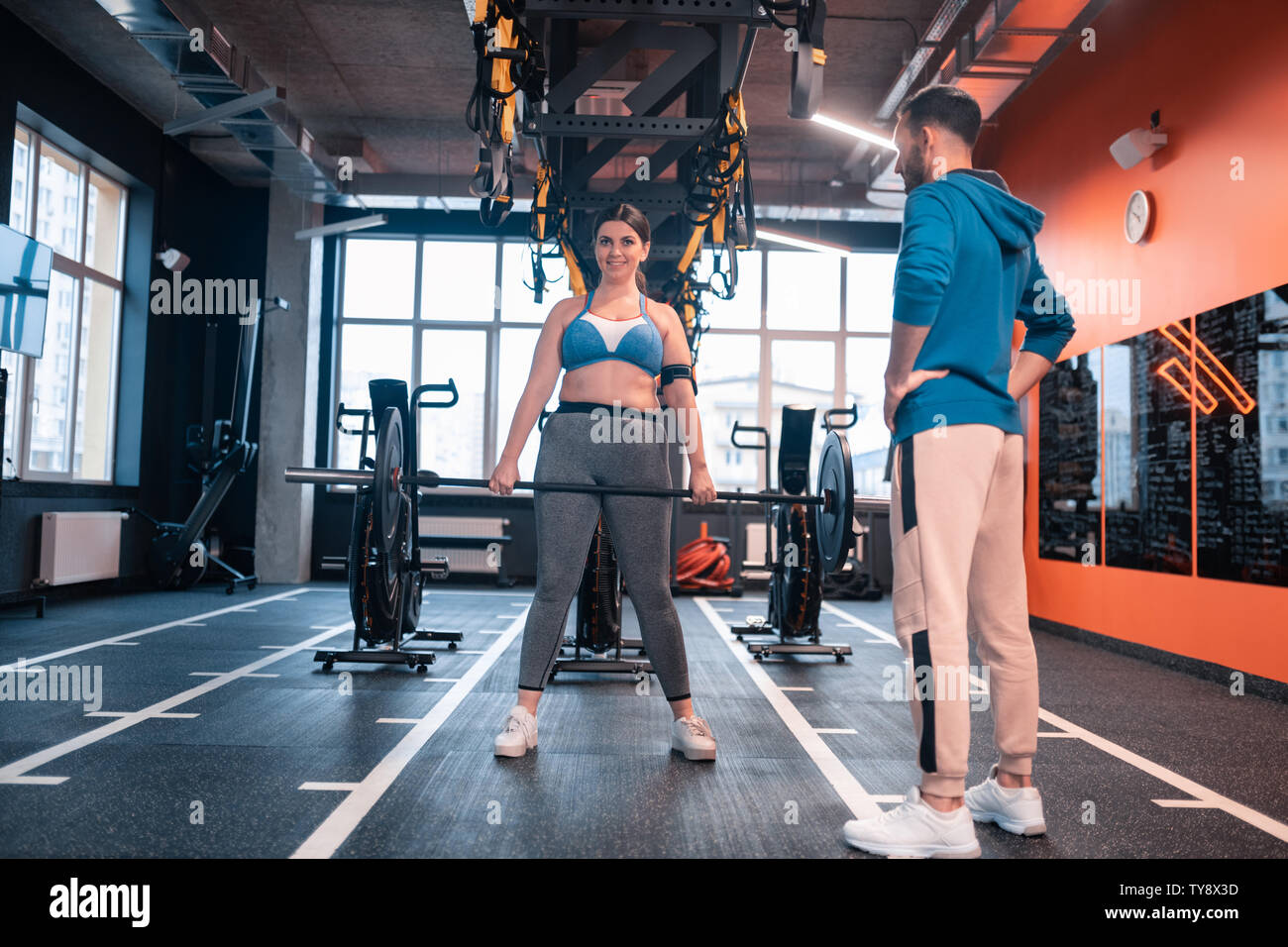 Overweight woman holding barbell while working out Stock Photo - Alamy