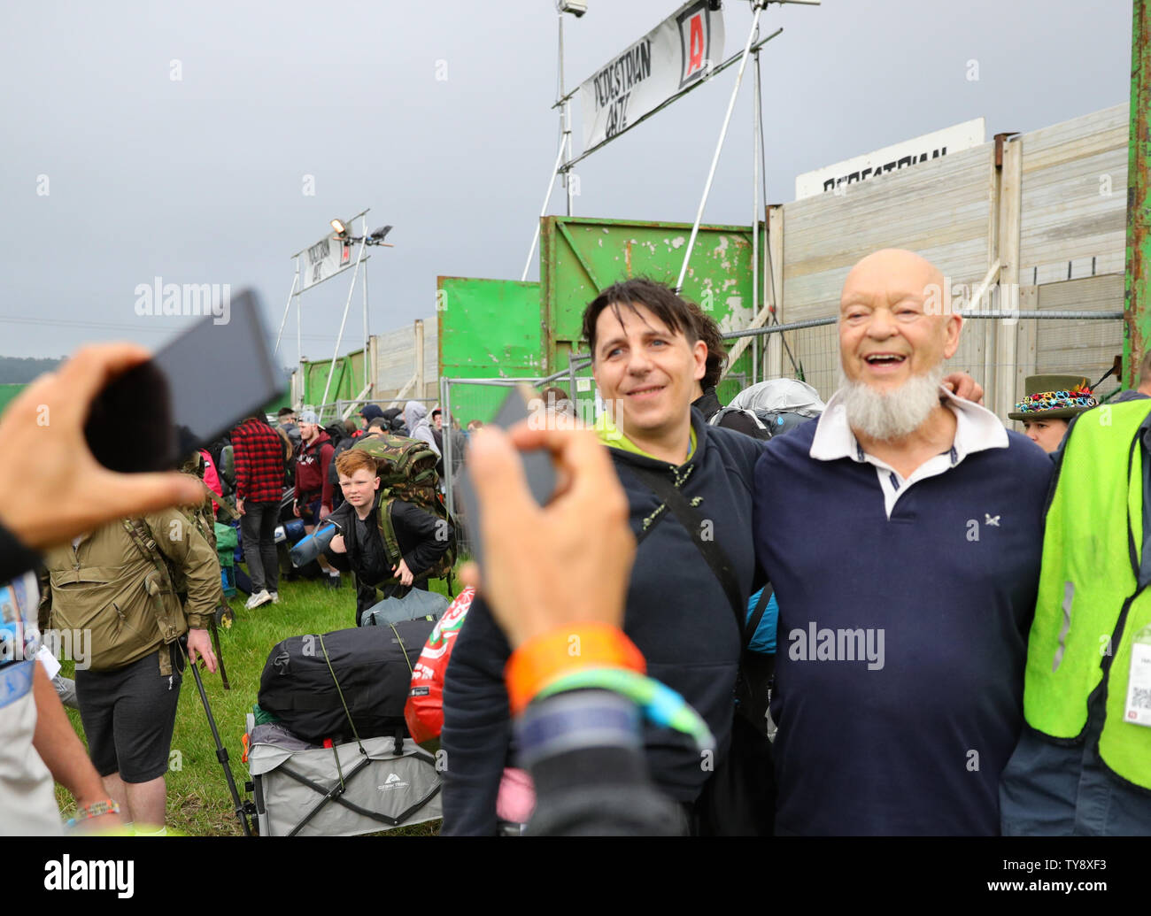 Festival organiser Michael Eavis (right) takes pictures with fans as ...