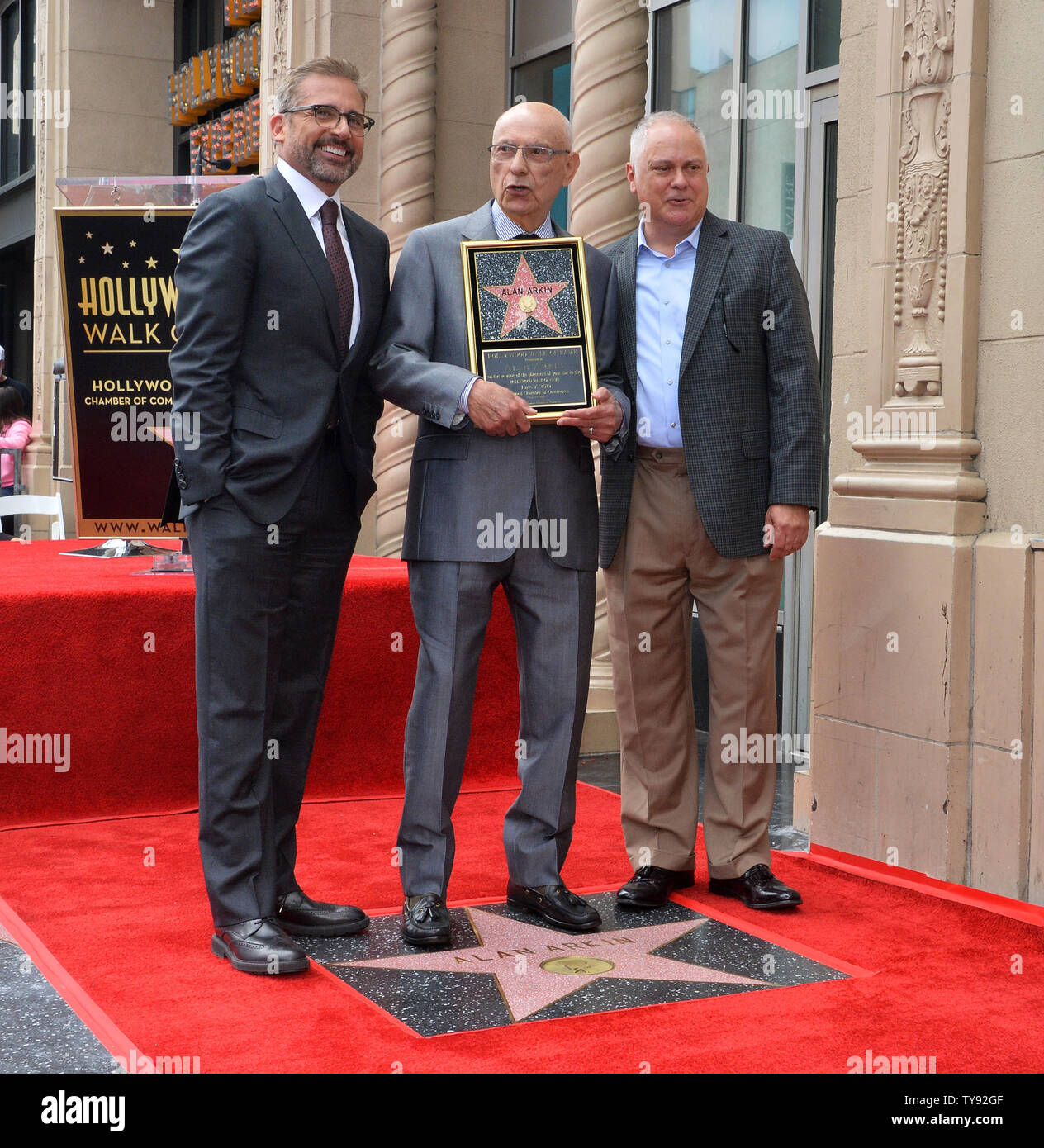 Actor Alan Arkin (C) holds a replica plaque as he is joined by actor ...