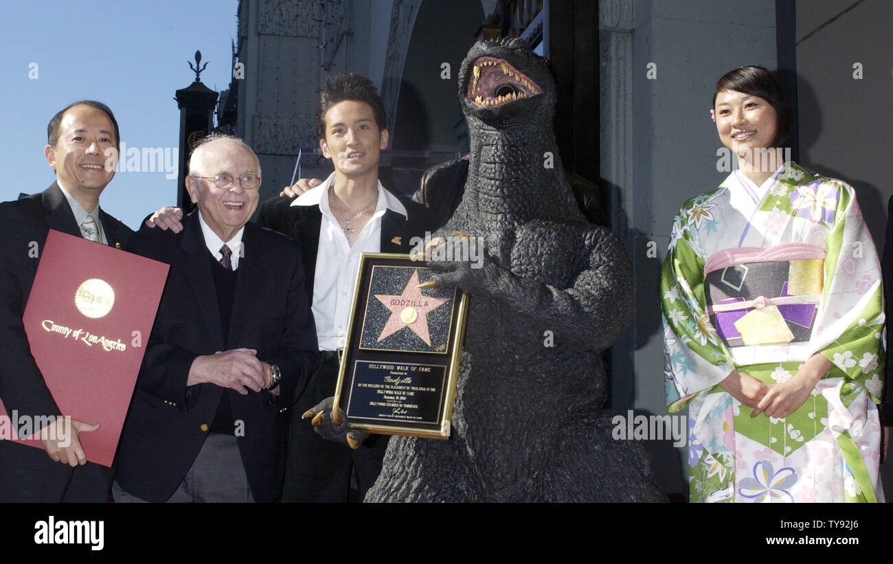 Film character "Godzilla" holds a replica plaque while posing with ...