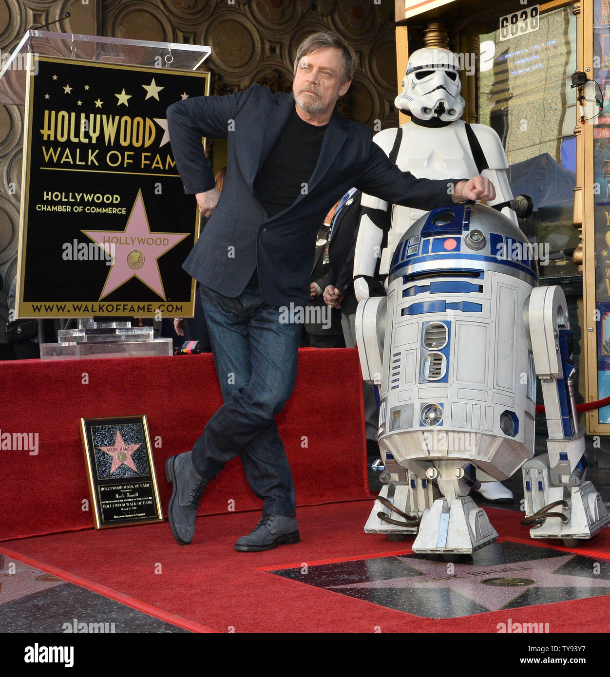 Actor Mark Hamill leans on R2-D2 during an unveiling ceremony honoring ...
