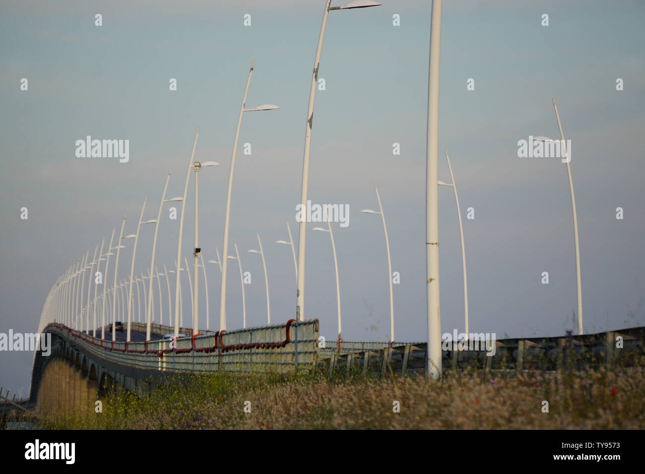 long crossing stone bridge on the ocean between the mainland and the ...