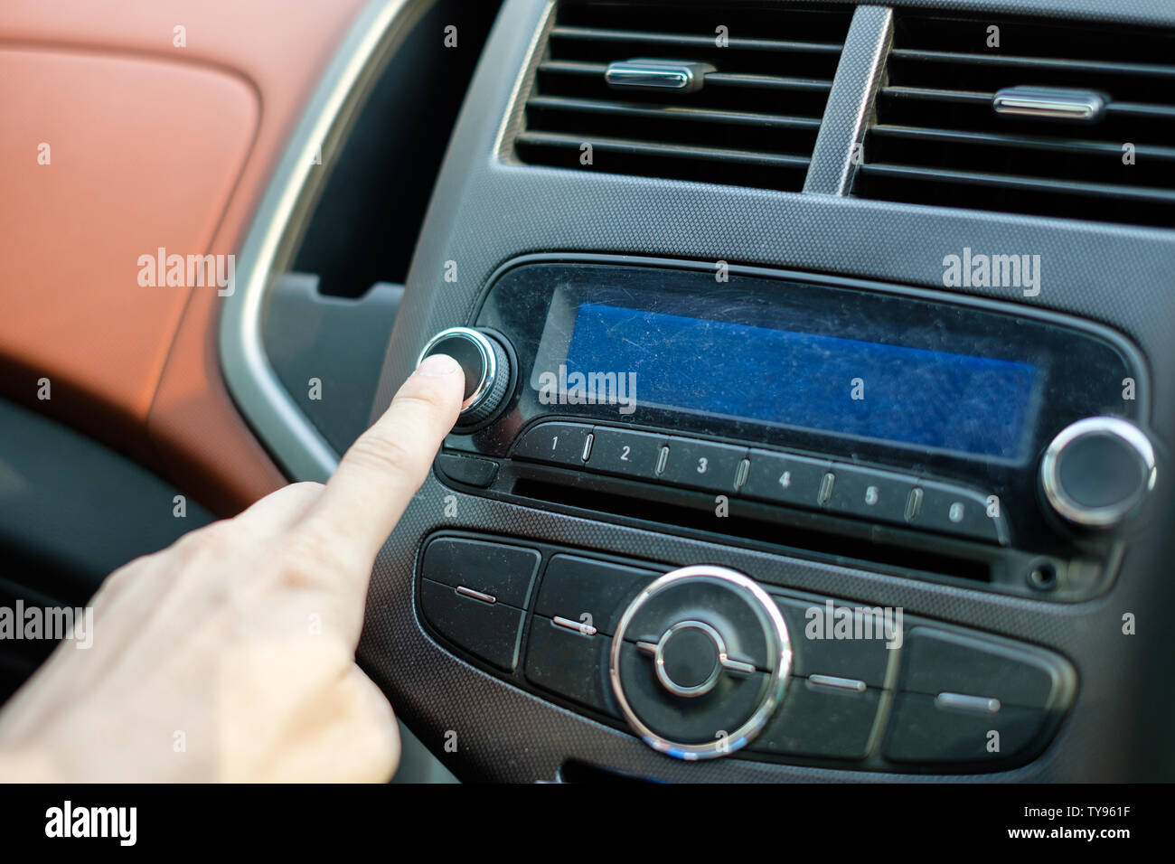 Man hand adjusting press button car audio control Stock Photo - Alamy