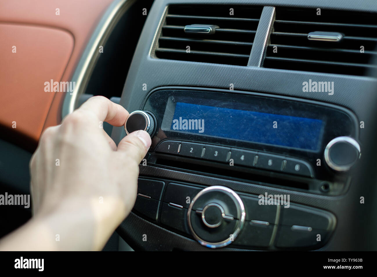 Man hand adjusting dial button car audio control Stock Photo - Alamy