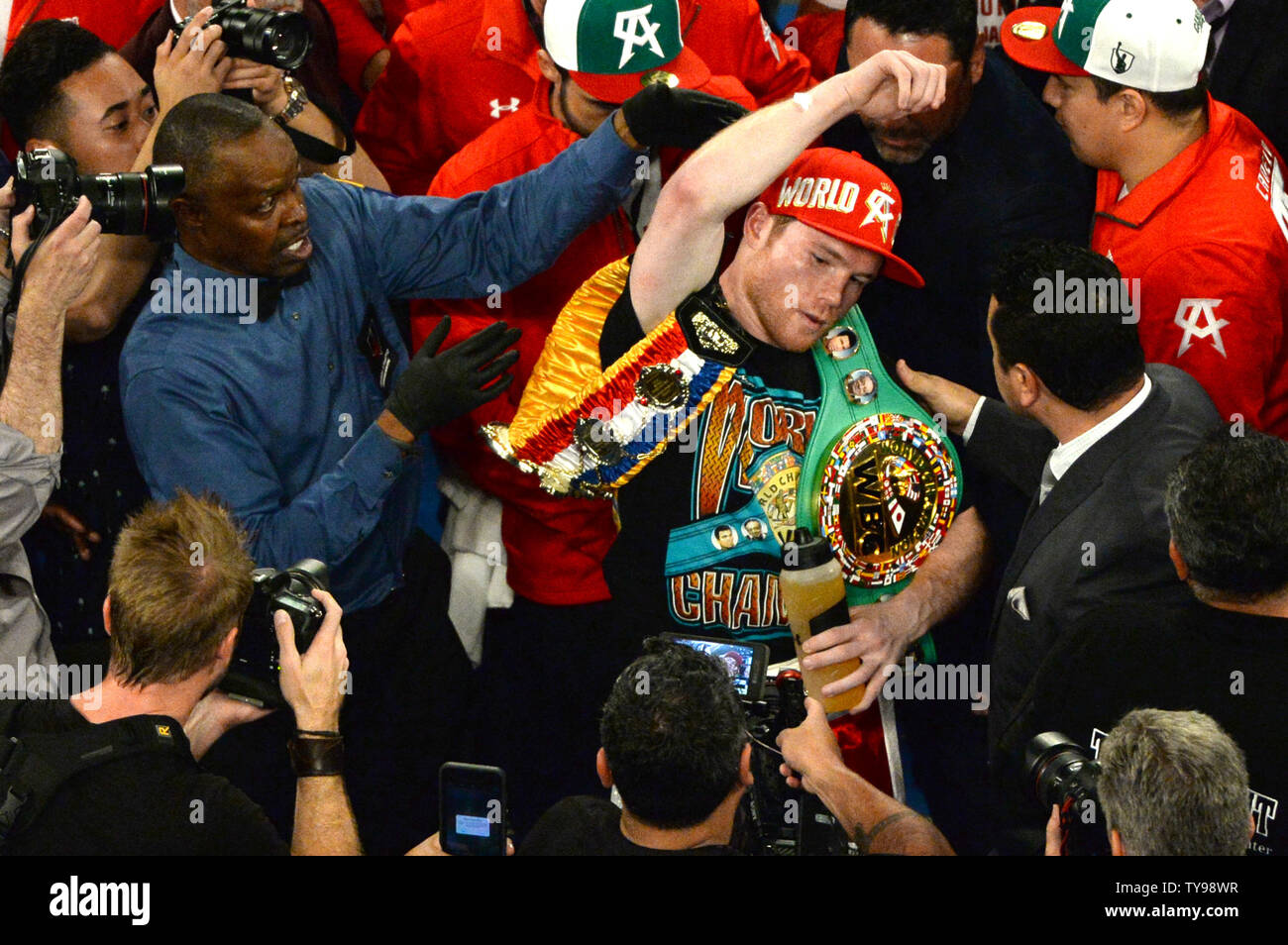 Canelo Alvarez puts his World Championship belts on his shoulders after ...