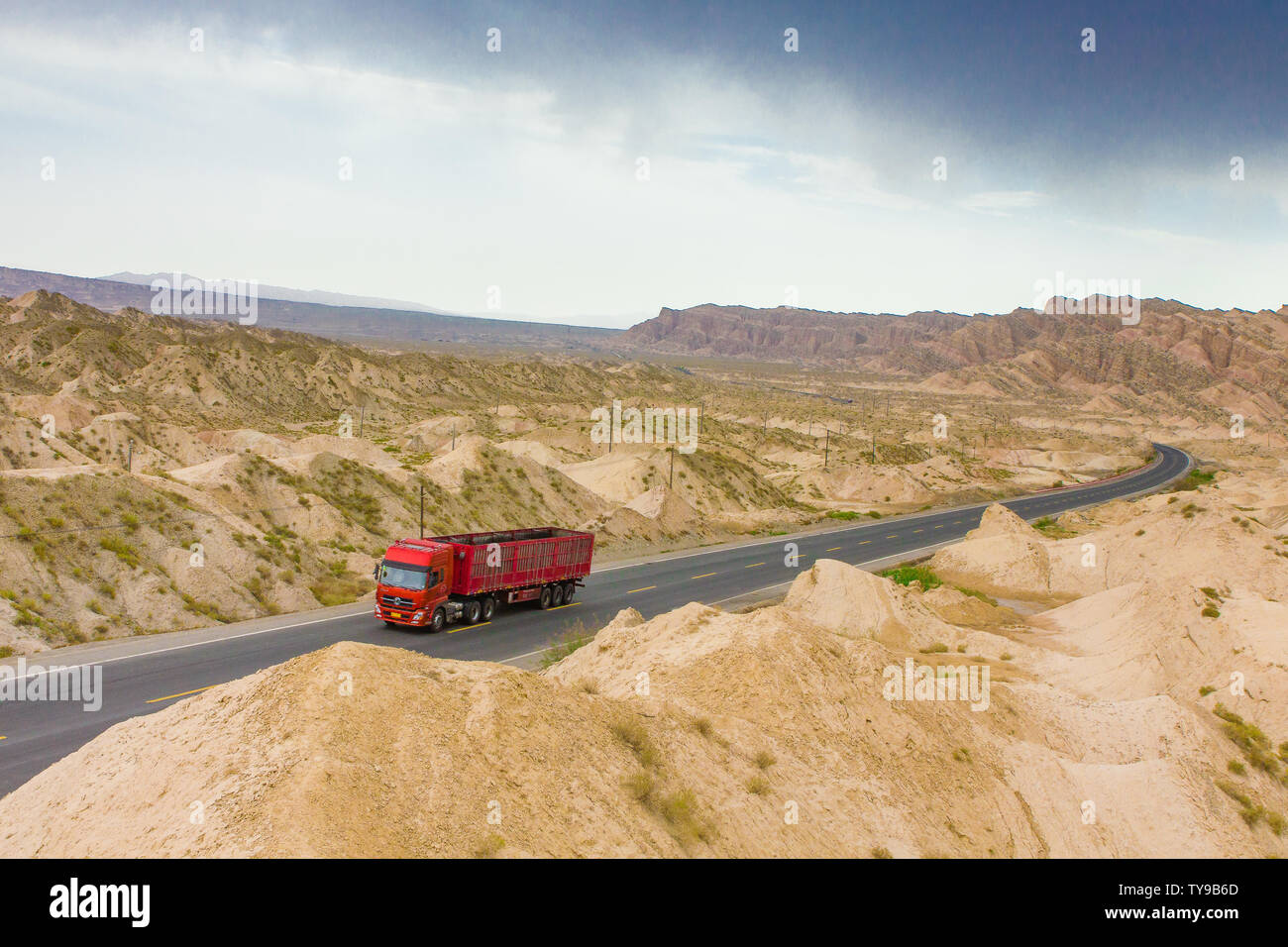 A car is on the road next to the Gobi Desert in Baicheng County ...