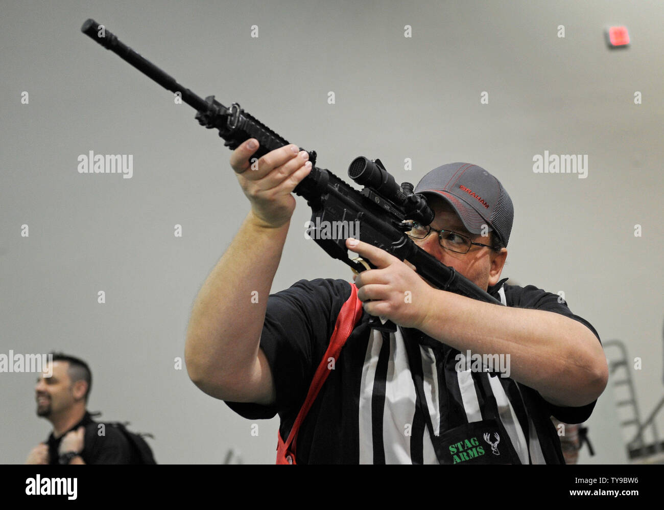 An attendee examines a rifle site at the Trijicon booth at the National ...