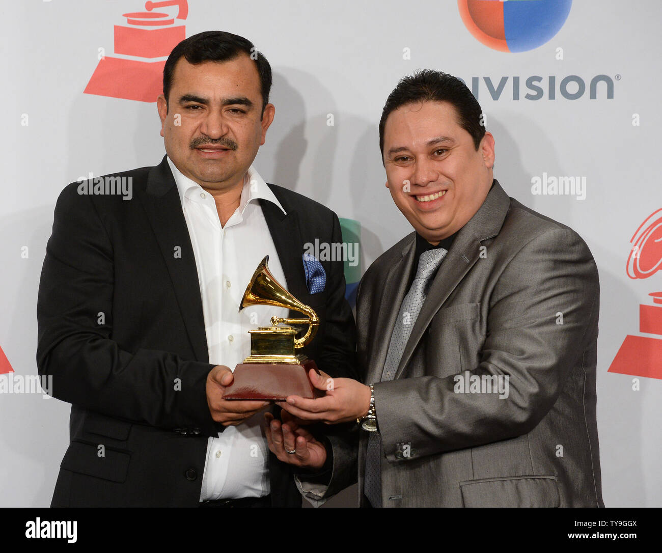 Members of Conjunto Primavera pose backstage with the award for Best ...