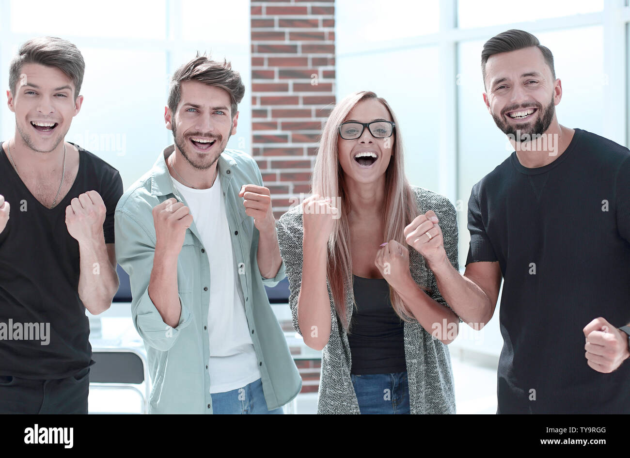 portrait of youth guys victoriously raising their fists up and ...
