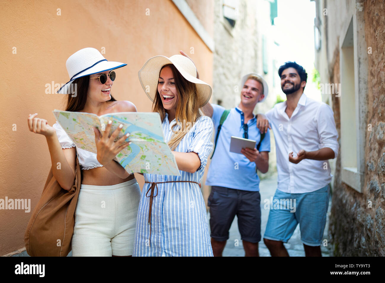 Group of friends tourists with map in old city on vacation Stock Photo ...