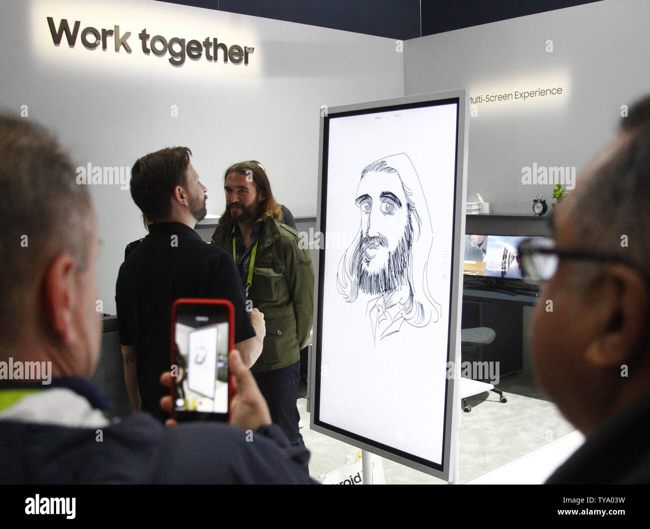 An artist makes a digital pencil drawing of an attendee on a Samsung ...
