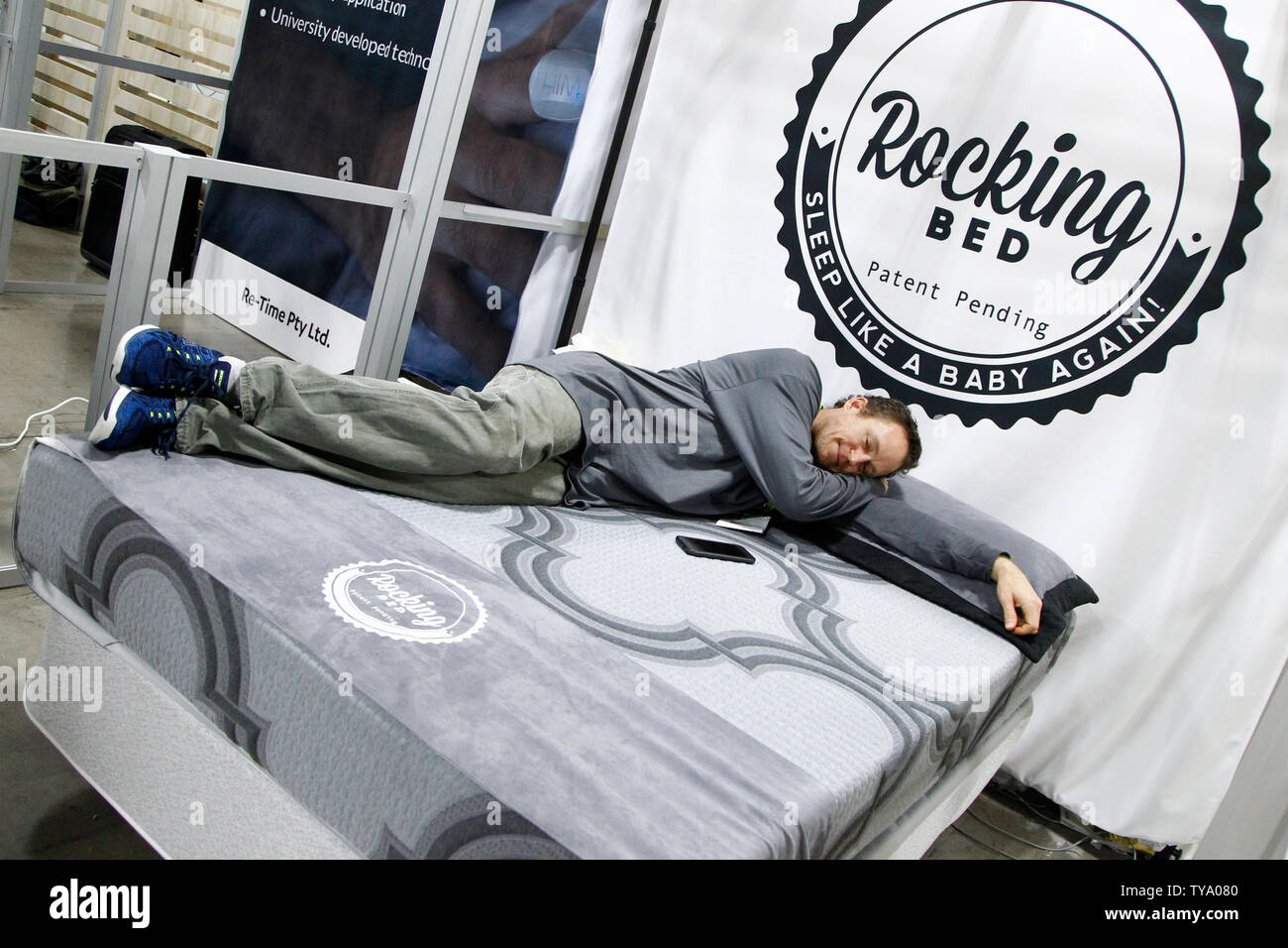 An attendee lays on the Rocking bed, designed to help people sleep ...