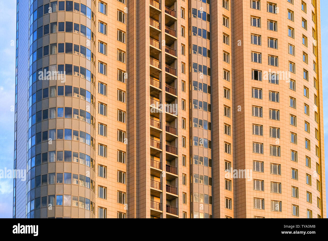 Modern multi-storey building with a glass facade. The evening sunset ...