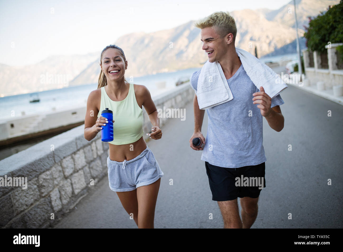 Happy fit people running and jogging together in summer sunny nature ...