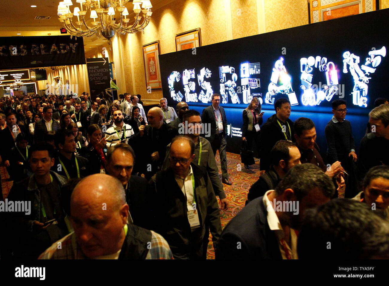 A view of a congested hallway of attendees walking past a large 'CES ...