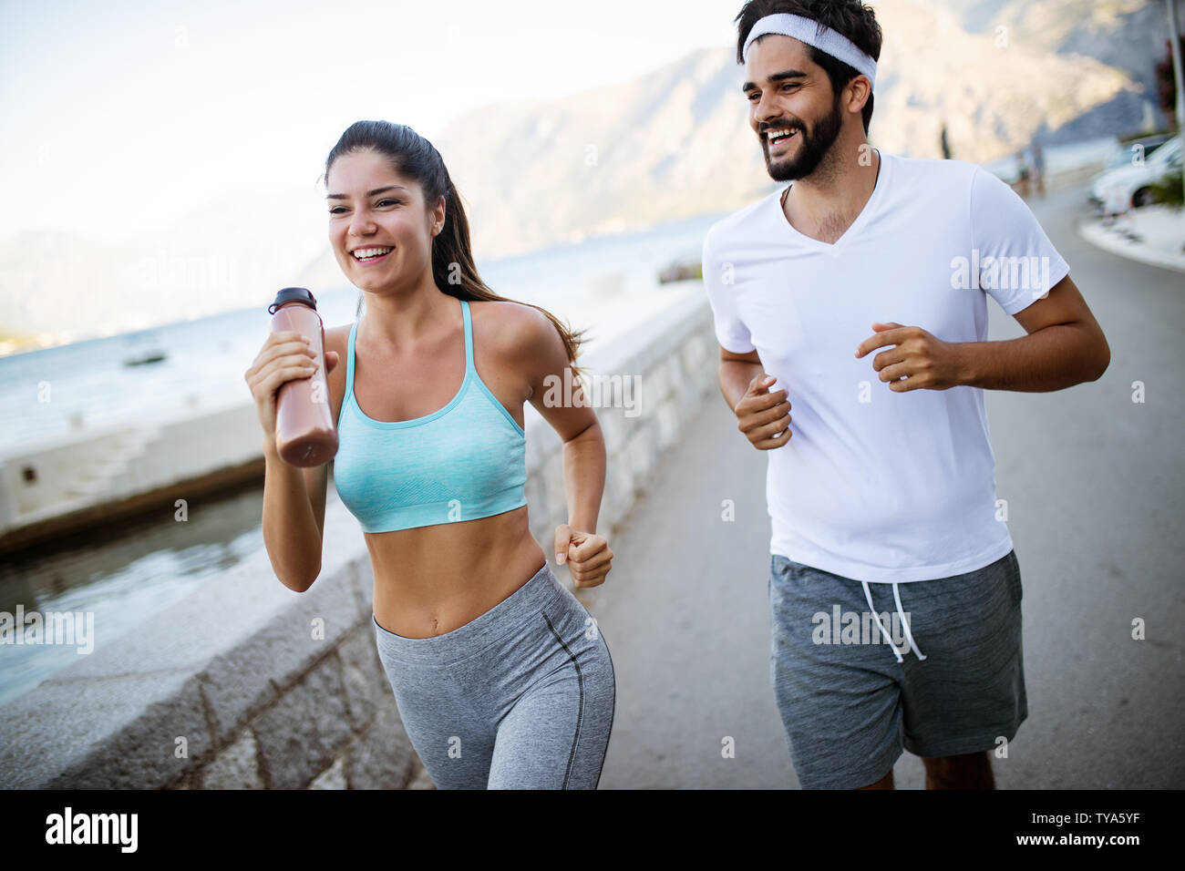 Happy fit people couple jogging and running outdoors Stock Photo - Alamy