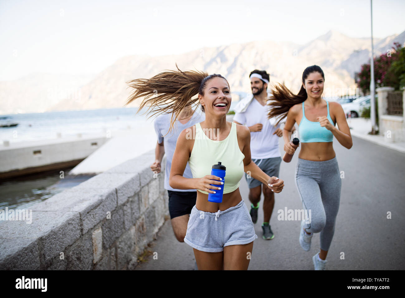 Outdoor portrait of group of friends running and jogging in nature ...