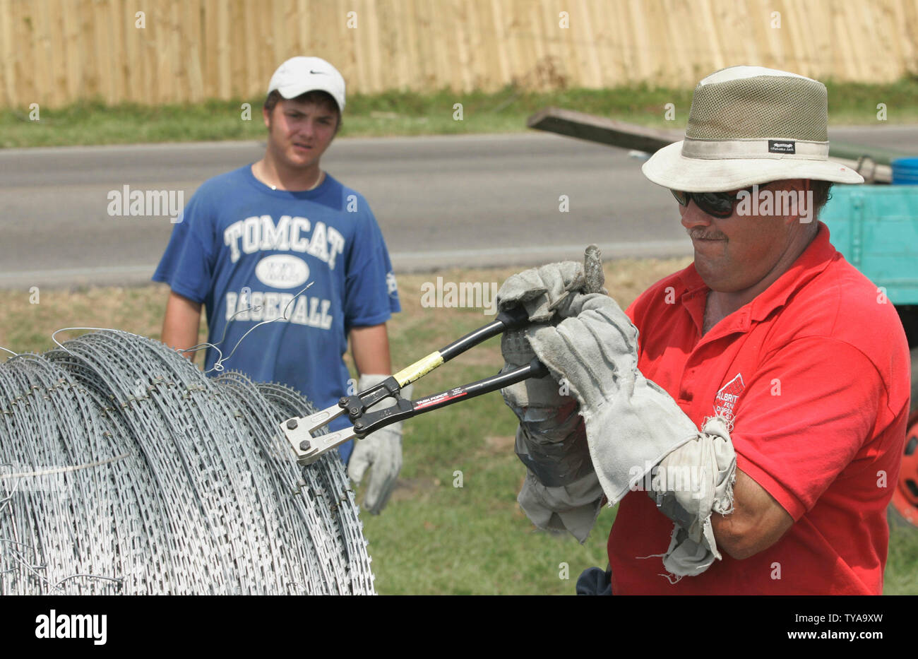 Raymond Skinner (right) of Biloxi, MS, pops open a bundle of concertina ...