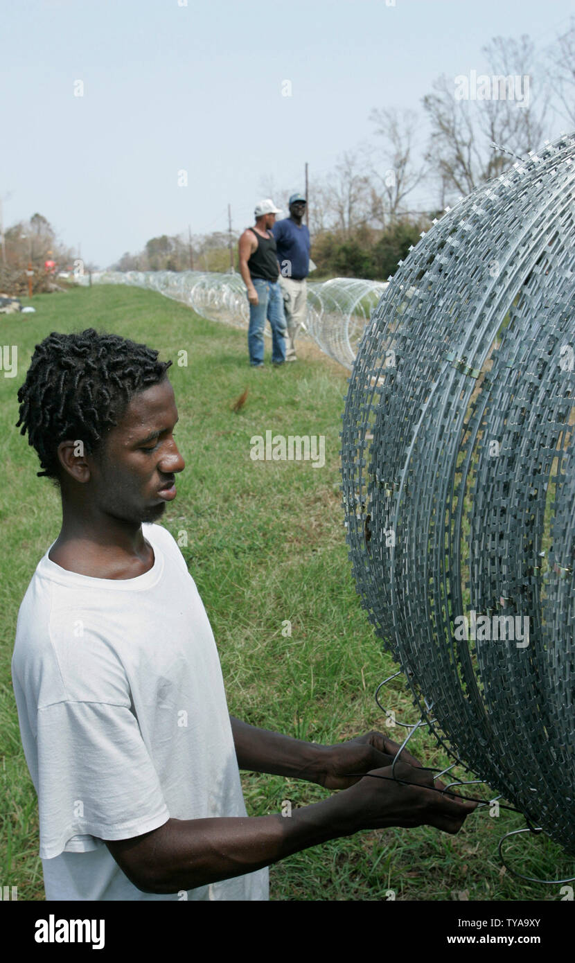 Marcus Taylor (bottom left) of Long Beach, MS, ties together bundles of ...