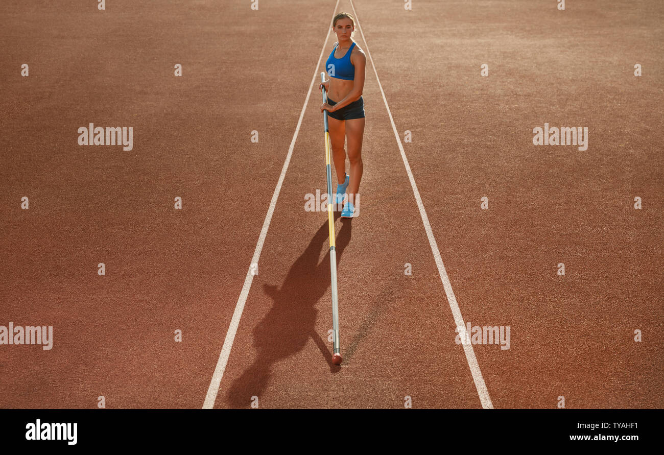 Professional female high jumper training at the stadium in sunny day ...