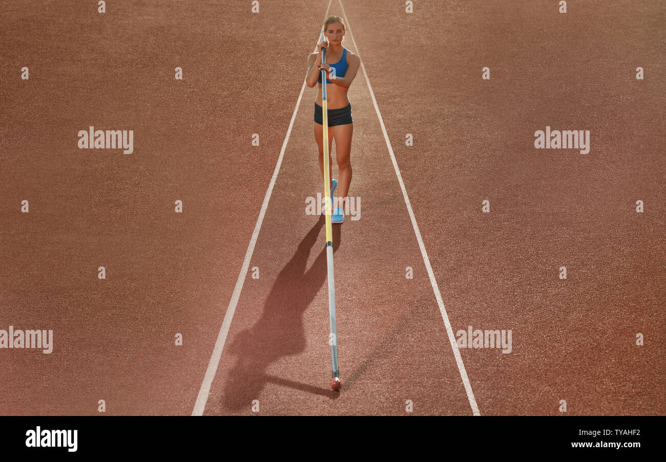 Professional female high jumper training at the stadium in sunny day ...
