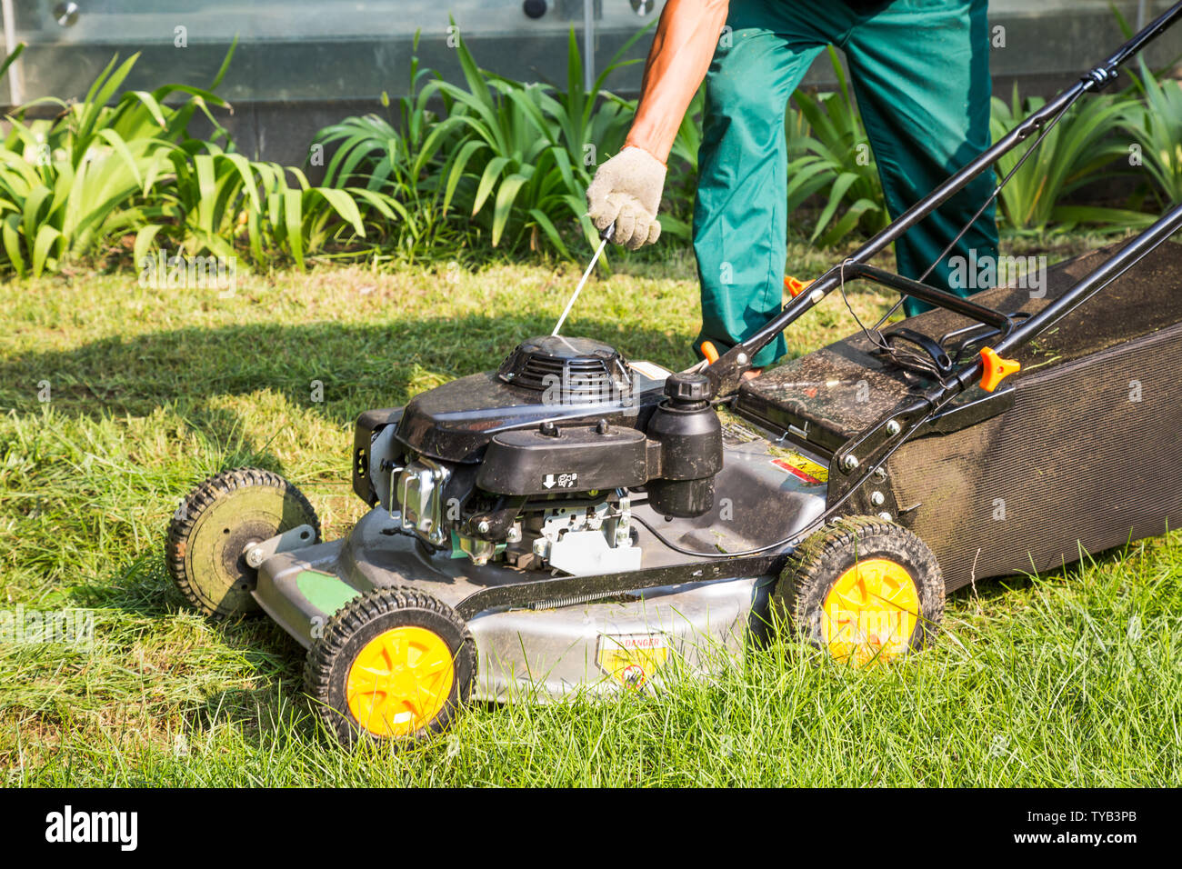 Landscape workers activate lawnmower Stock Photo - Alamy