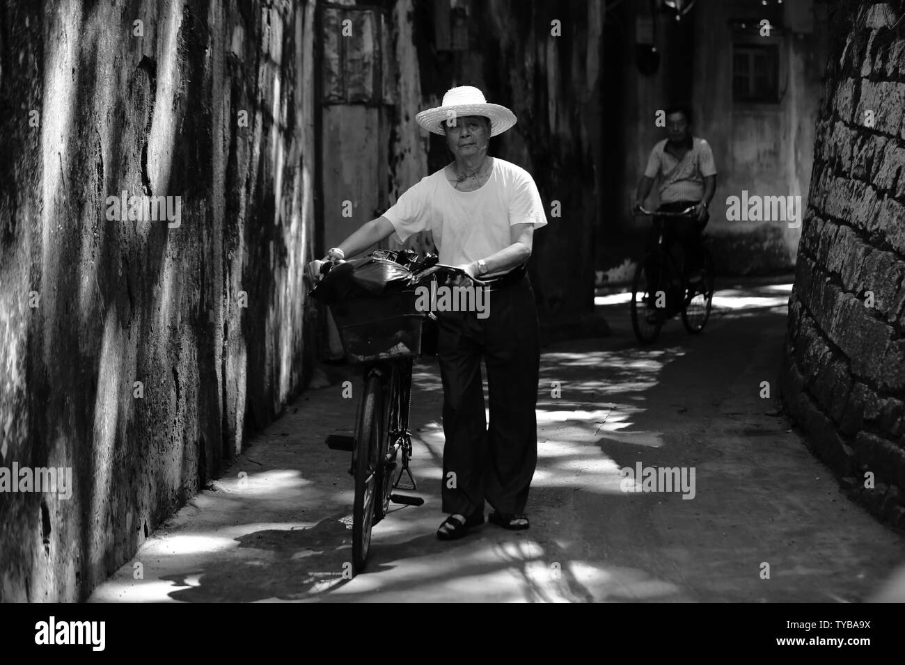 Old town street, old man pushing bicycles Stock Photo - Alamy