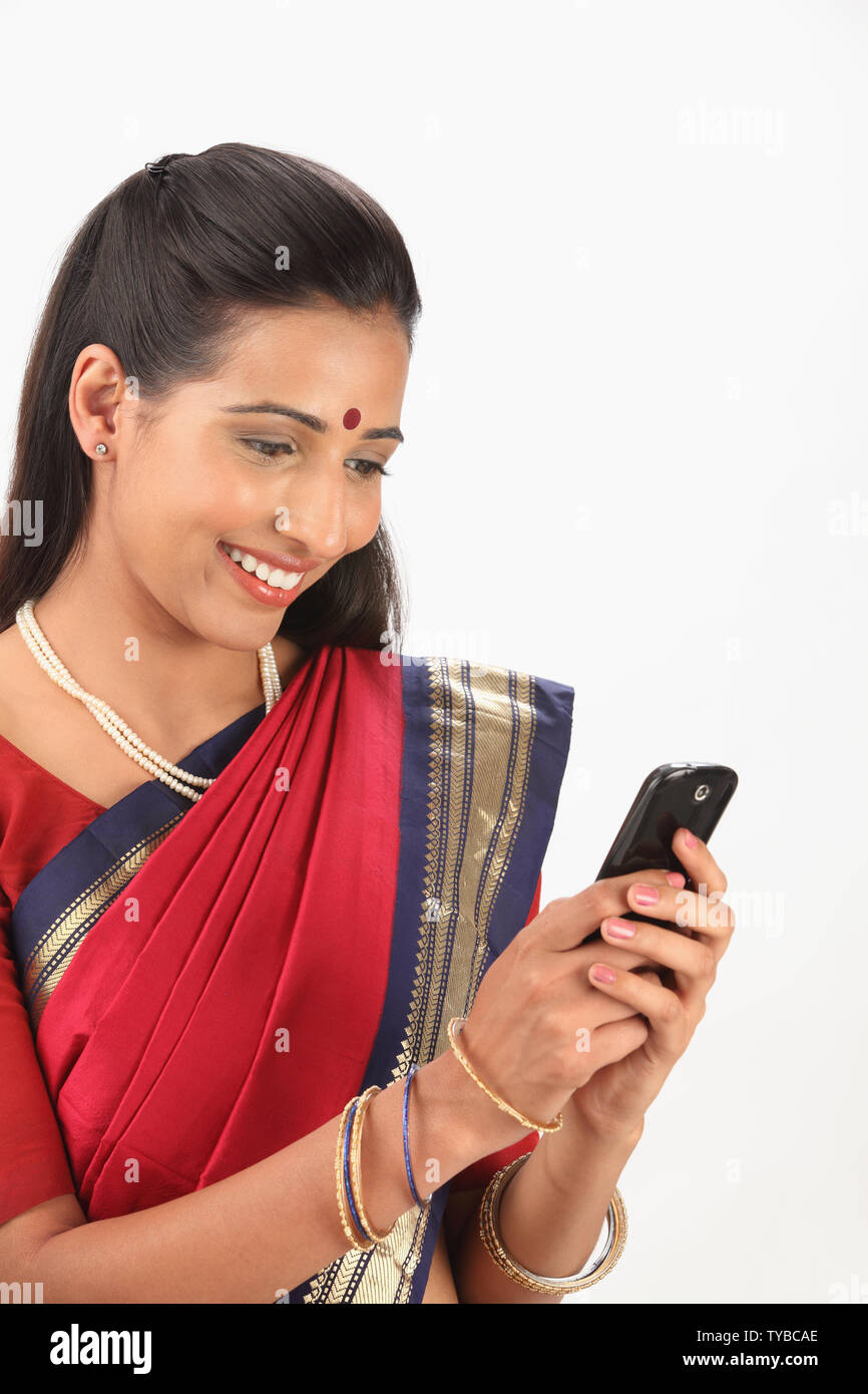 Indian woman text messaging and smiling Stock Photo - Alamy