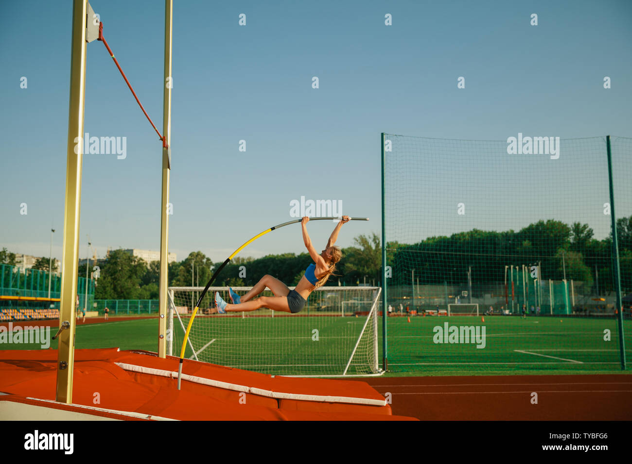Professional female high jumper training at the stadium in sunny day ...