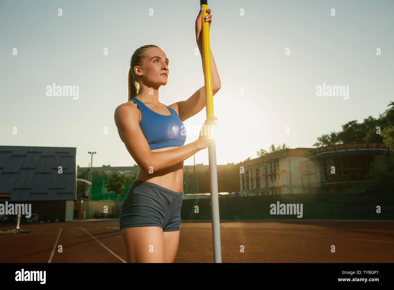 Professional female high jumper training at the stadium in sunny day ...