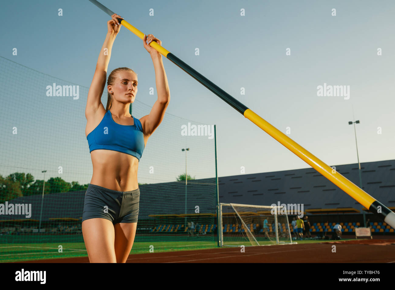 Professional female high jumper training at the stadium in sunny day ...