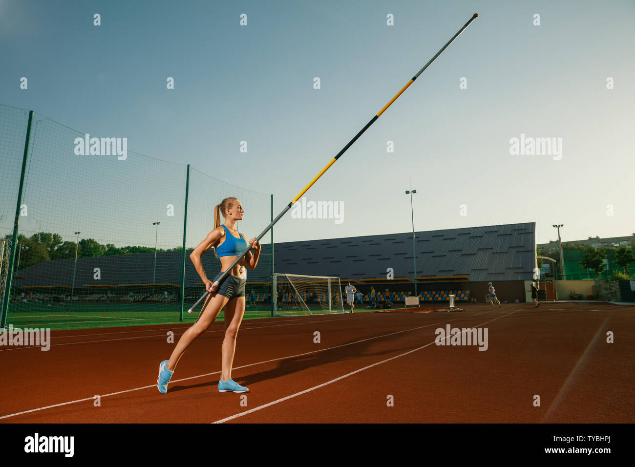 Professional female high jumper training at the stadium in sunny day ...