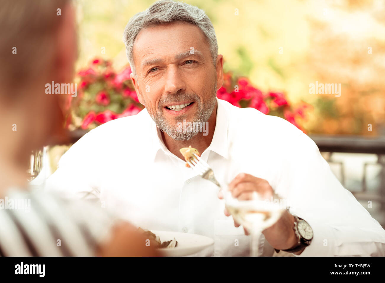 Handsome bearded mature man eating and talking to his wife Stock Photo ...