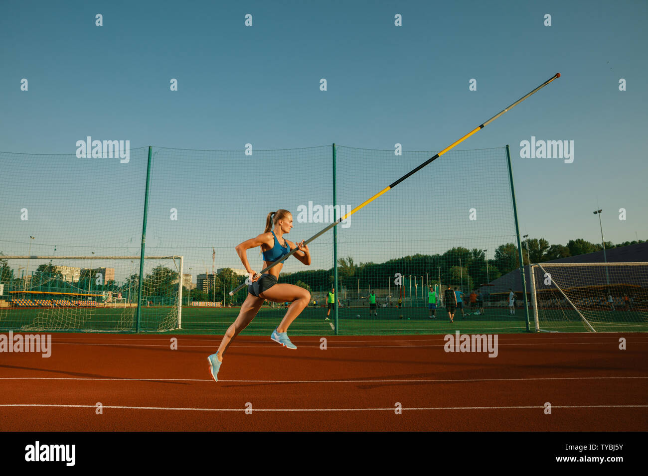 Professional female high jumper training at the stadium in sunny day ...