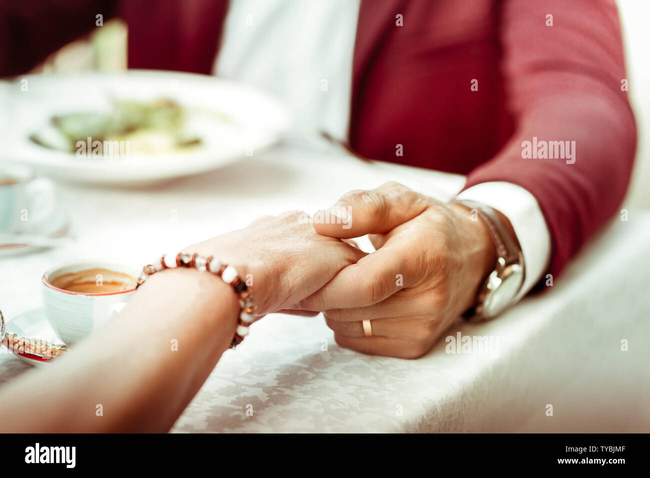 Close up of loving husband wearing watch touching hand of his wife ...