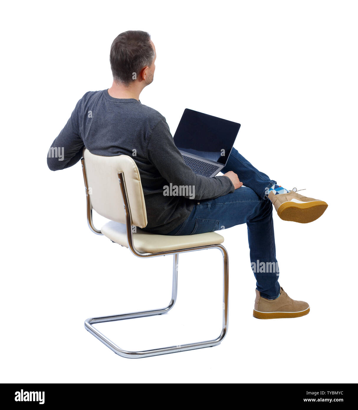 Back view of a man who sits on a chair with a laptop. Rear view people ...