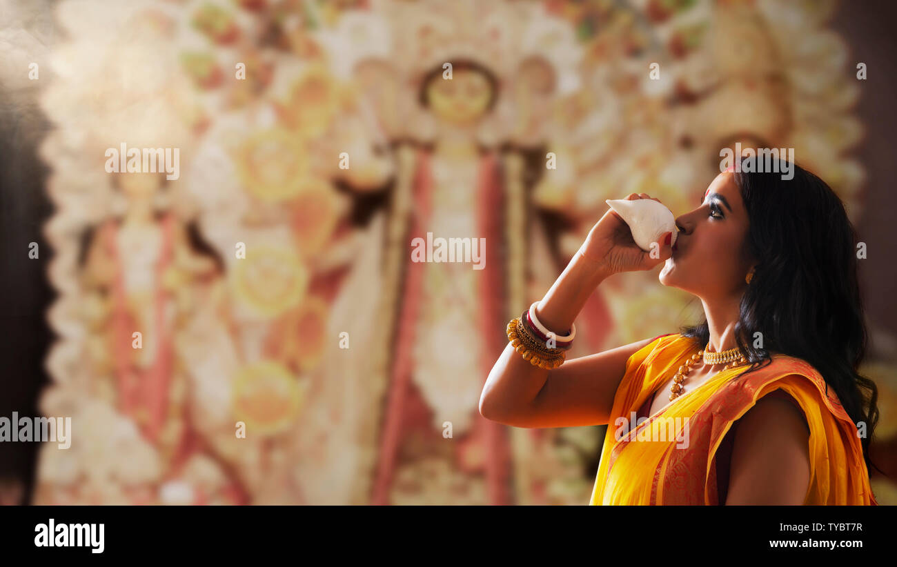 "Portrait of a beautiful Married Bengali woman blowing , during Durga ...