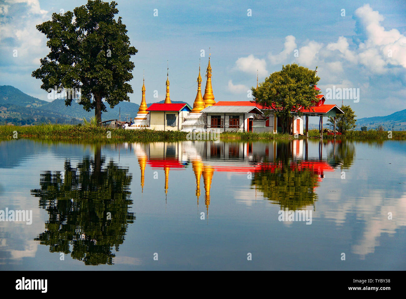 Pagoda with golden rooftops mirroring in the water of Inlay Lake, Burma ...