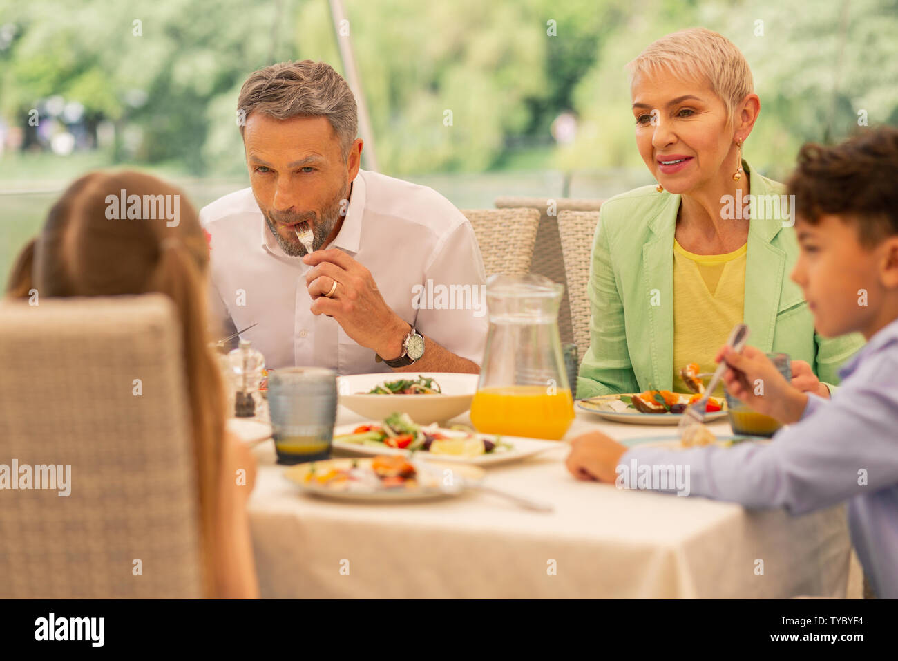 Grandparents and sister with brother having delicious breakfast Stock ...
